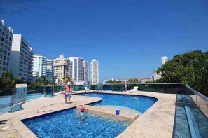 Piscina com paisagem urbana ao fundo.