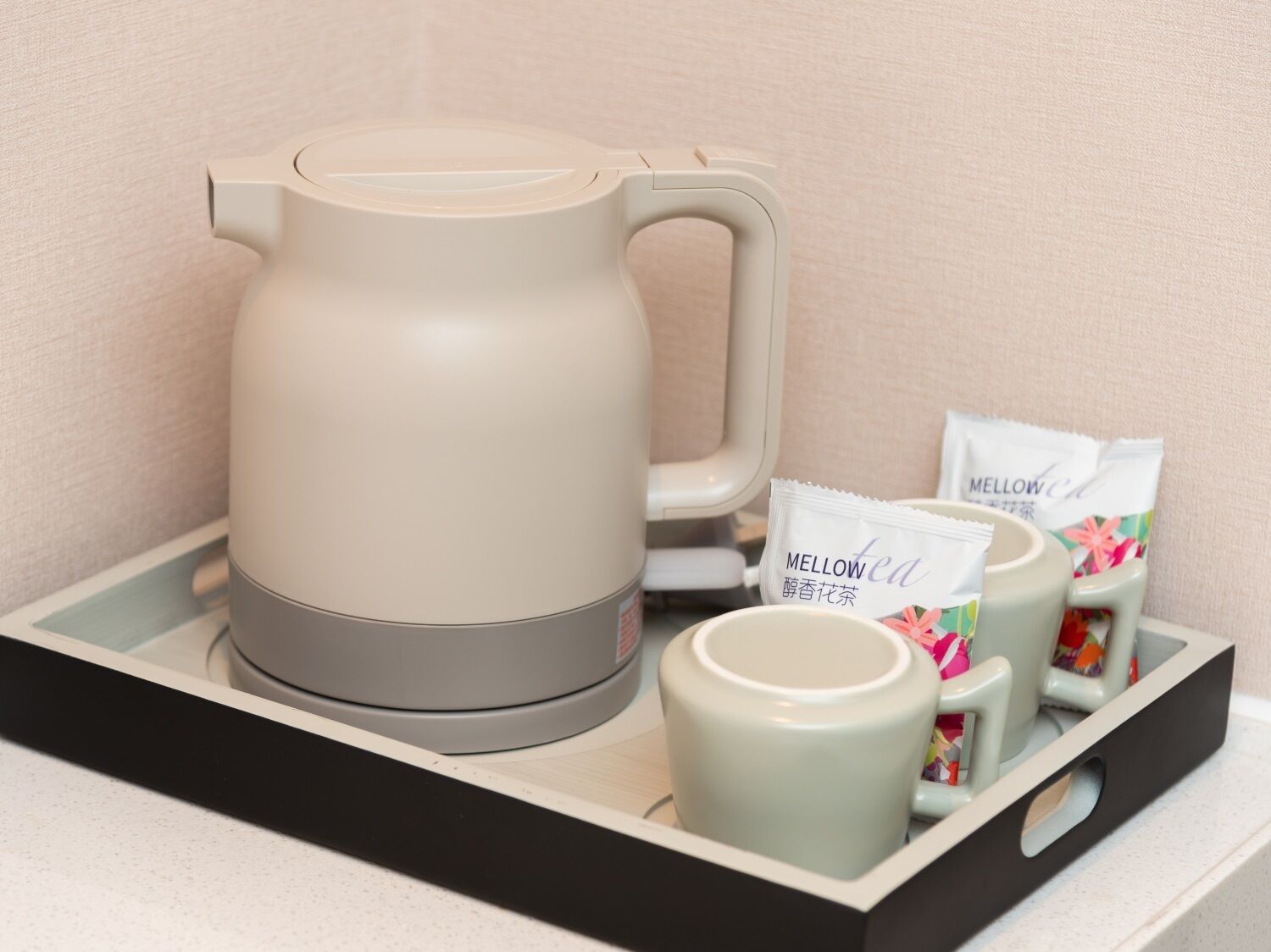 Um conjunto de chá com chaleira, caneca e sachês de chá sobre uma bandeja.