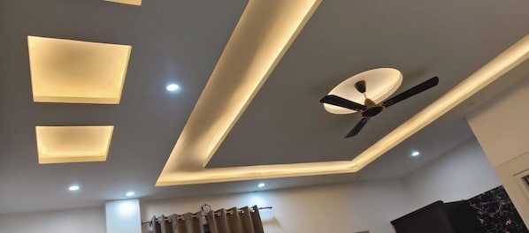Teto com iluminação embutida, ventilador de teto e design moderno.