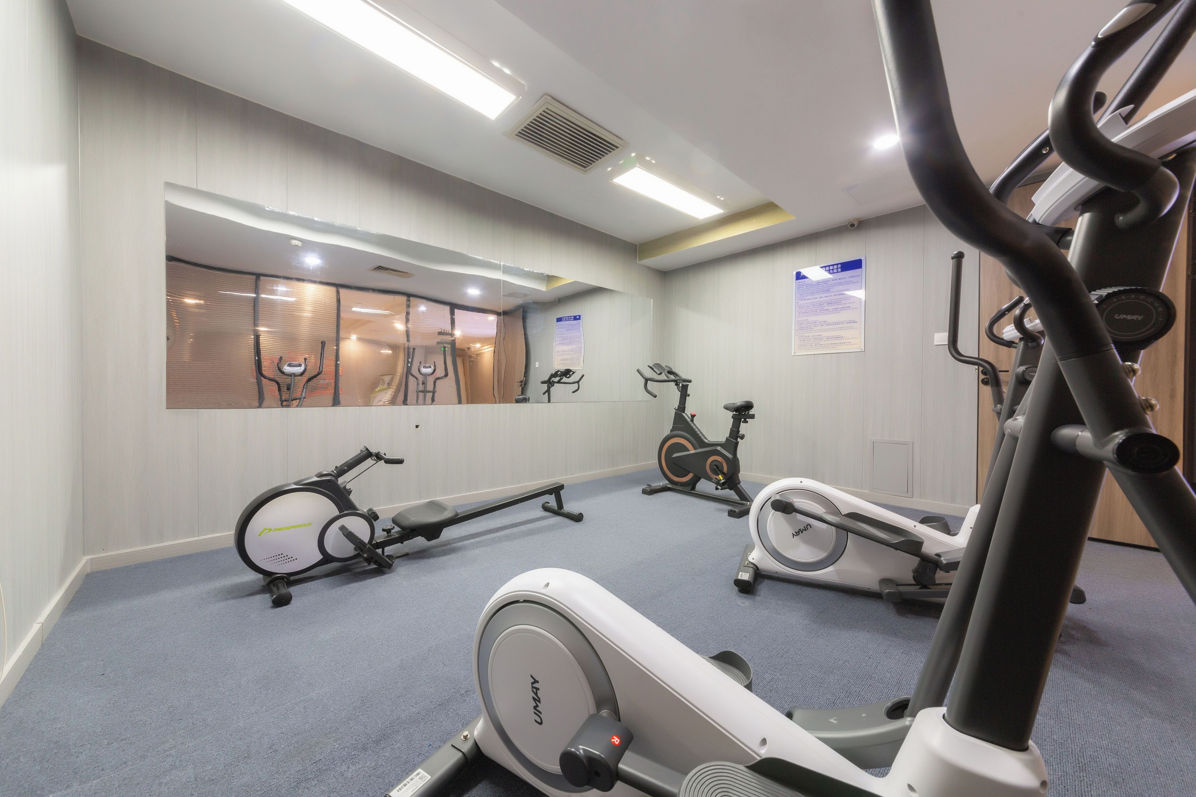 Academia com bicicletas ergométricas, esteiras e equipamentos de ginástica.