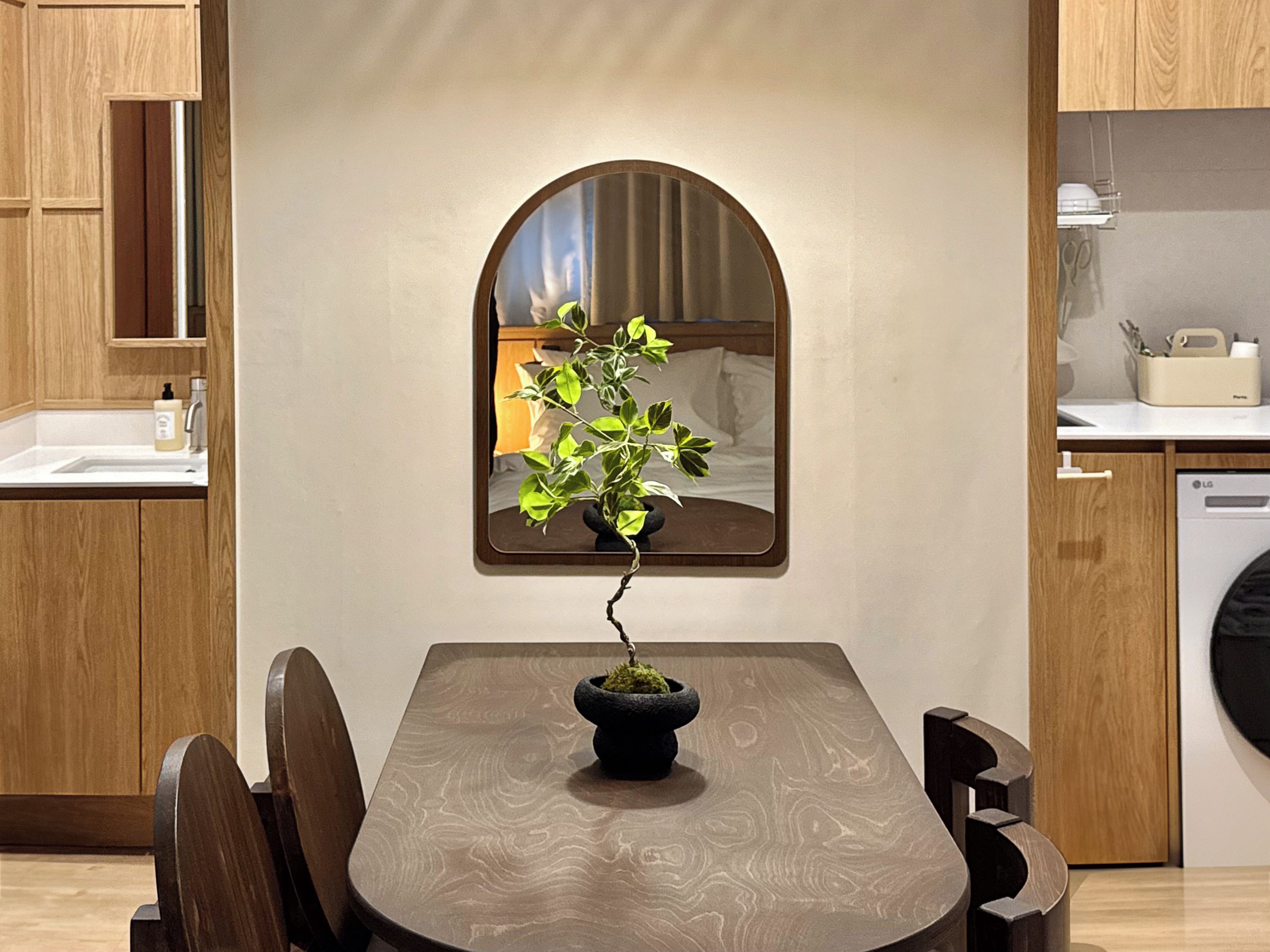 Cozinha moderna com armários de madeira, máquina de lavar louça embutida e mesa de jantar com cadeiras.