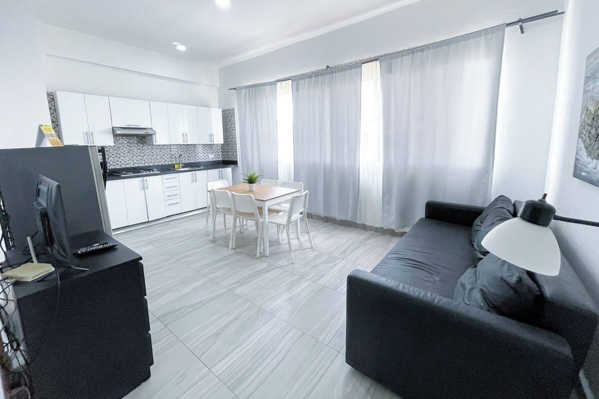 Um apartamento moderno com cozinha, sala de jantar e sala de estar.