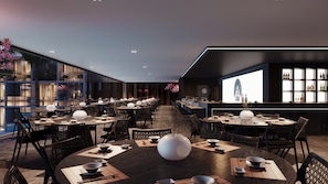 Interior moderno de restaurante com várias mesas, cadeiras pretas e um balcão de sushi.
