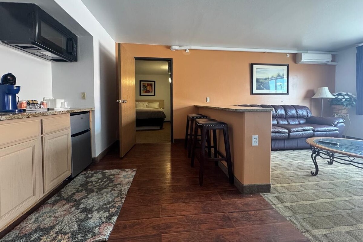 Um espaço compacto com cozinha compacta, área de refeições e sala de estar com sofá e mesa de centro.