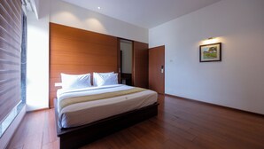 Um quarto moderno com uma cama grande, cabeceira de madeira e um quadro na parede.