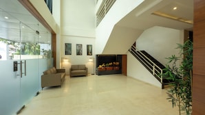 Um hall amplo com teto alto, escada e balcão de recepção.