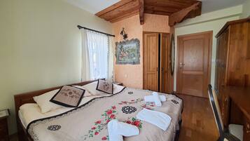 Quarto com cama, guarda-roupa de madeira e um quadro na parede.