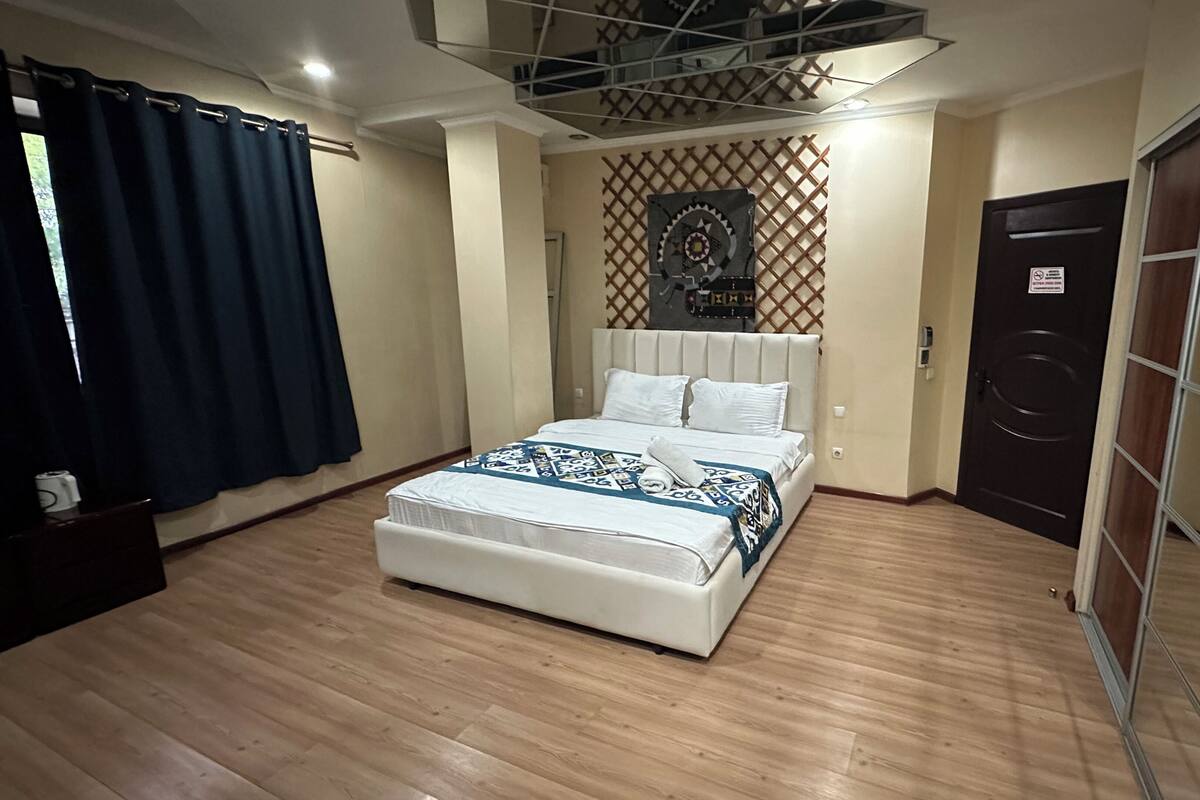 Quarto de hotel com cama, guarda-roupa, porta e teto com design em grade.