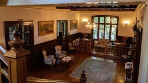 Um quarto amplo com escada de madeira, área de refeições e uma grande janela com vista.