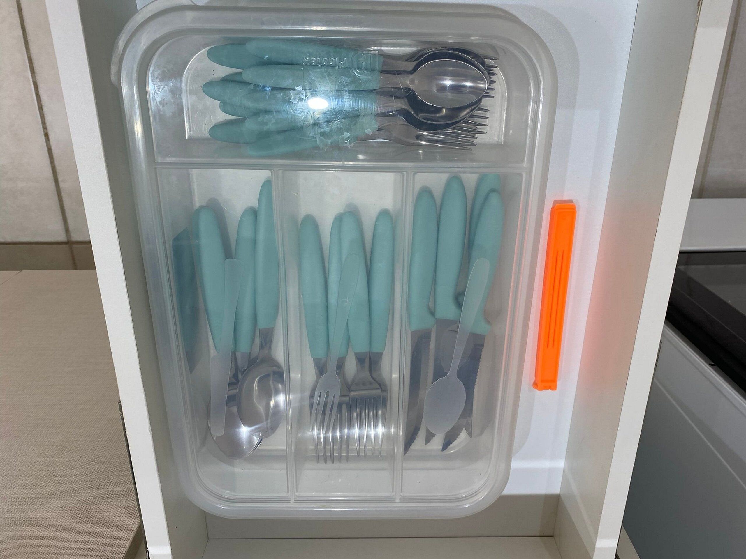 Um recipiente de armazenamento com utensílios de cozinha.