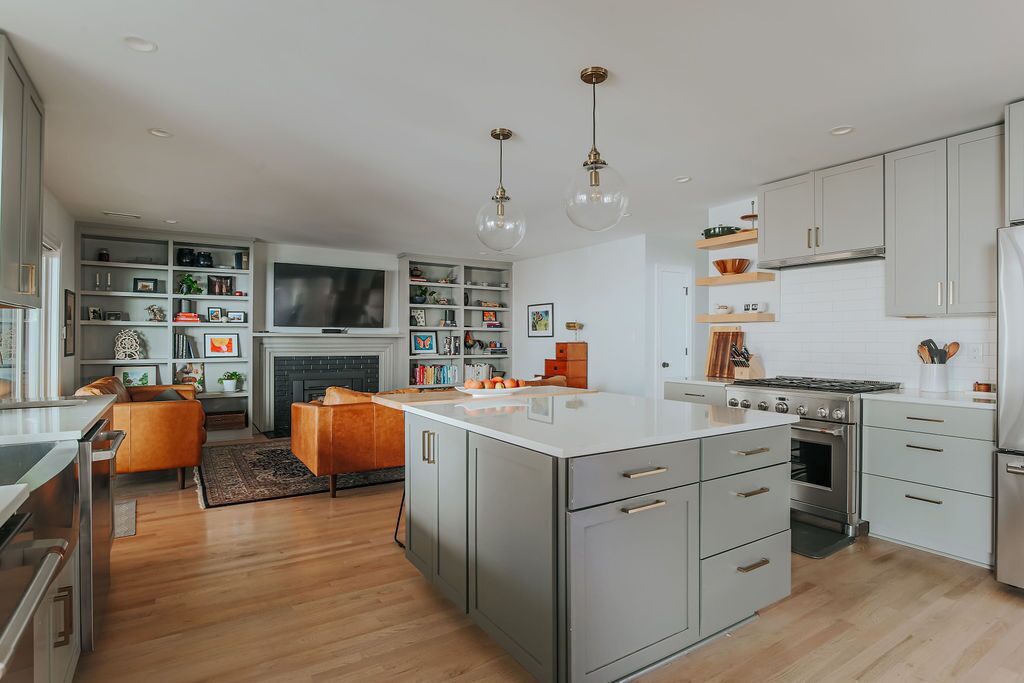 Uma cozinha moderna com ilha central, eletrodomésticos embutidos e lareira.
