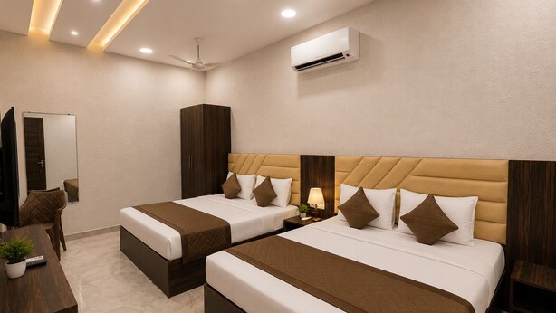 Quarto de hotel com duas camas, televisão, escrivaninha e espelho.