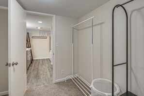 Casa de banho com chuveiro, porta-toalhas, sanita e porta que dá para um corredor.