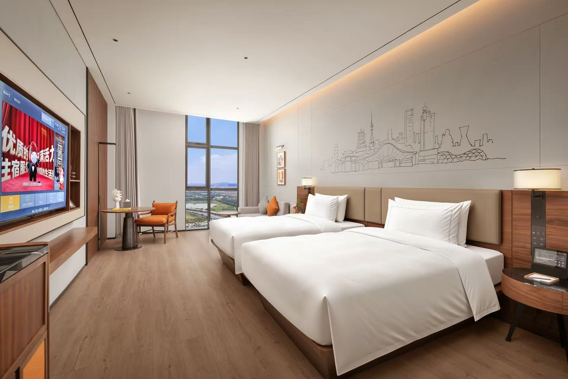 Quarto de hotel com duas camas, televisão, escrivaninha e um mural com vista para a cidade.