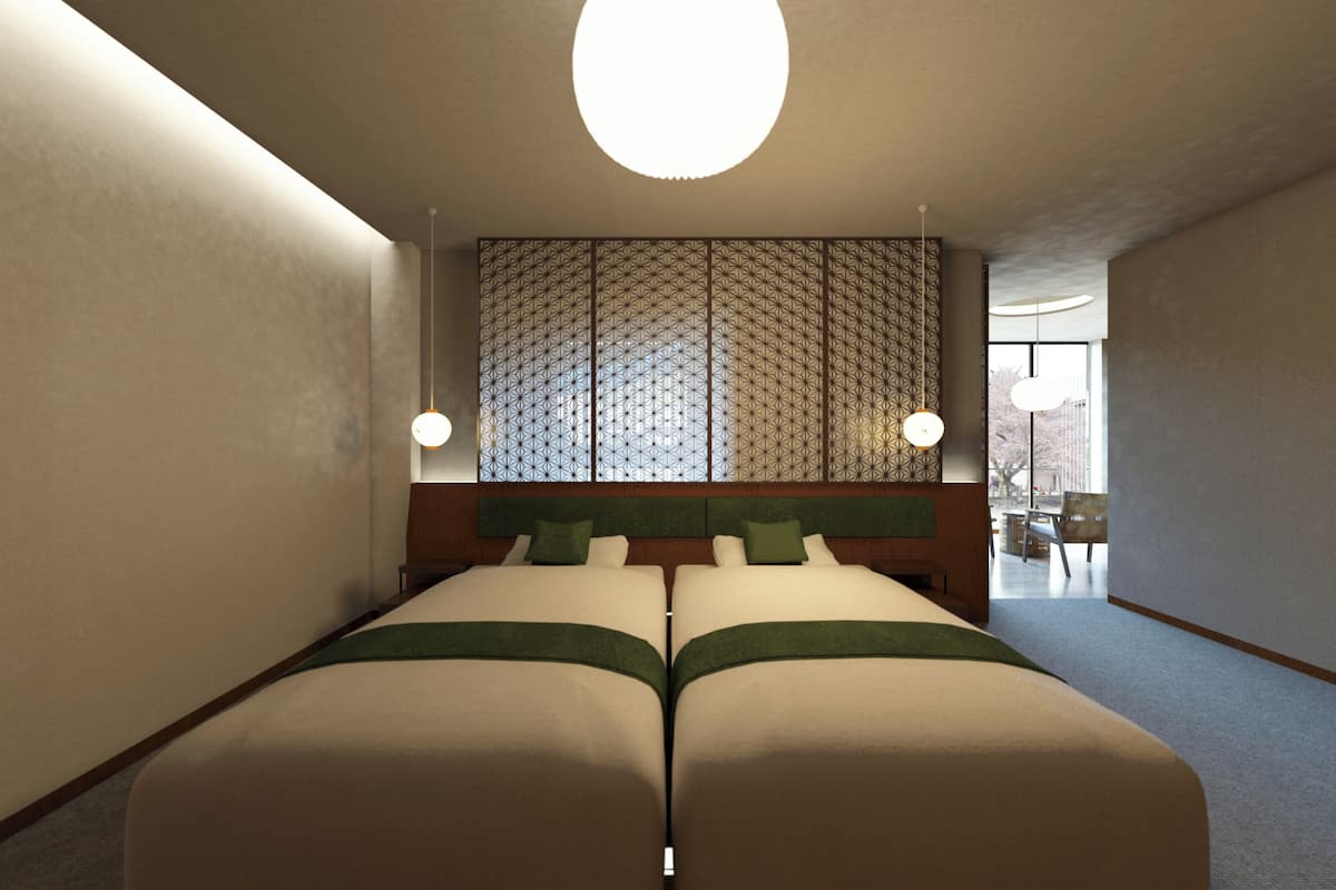 Quarto de hotel moderno com uma cama grande, duas mesas de cabeceira, uma cabeceira decorativa e uma janela ampla.