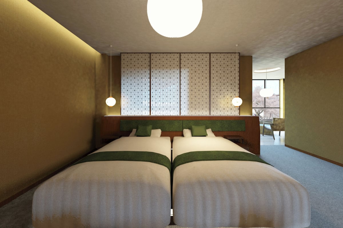 Quarto de hotel com uma cama grande, cabeceira decorativa, vista para o exterior e uma luminária no teto.