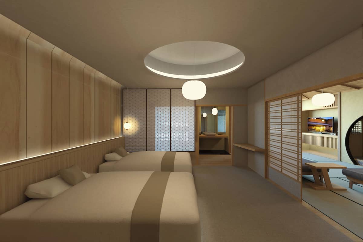 Quarto de hotel moderno com uma cama grande, um banheiro pequeno e uma TV no canto.