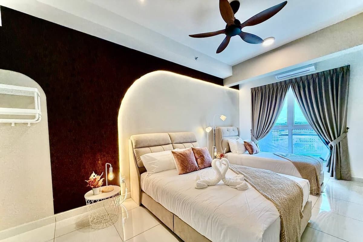 Quarto moderno com uma cama grande, ventilador de teto e vista para a cidade.