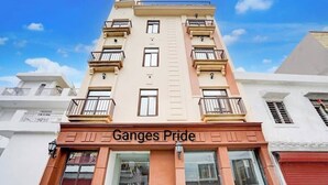 Um edifício de vários andares com uma placa indicando 'Ganges Pride' no nível da rua.
