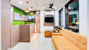 Uma sala de estar moderna com um sofá, uma televisão e um ventilador de teto.