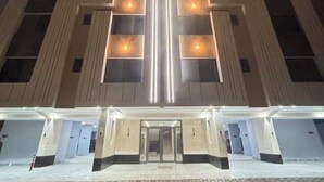 Um hotel de vários andares com fachada simétrica, grandes janelas e entrada central.