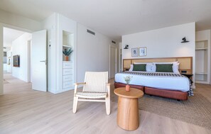 Quarto com cama, cadeira, mesa redonda e guarda-roupa.