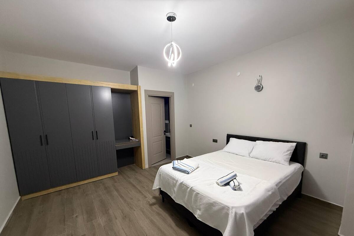 Quarto com cama, guarda-roupa e porta para um banheiro.