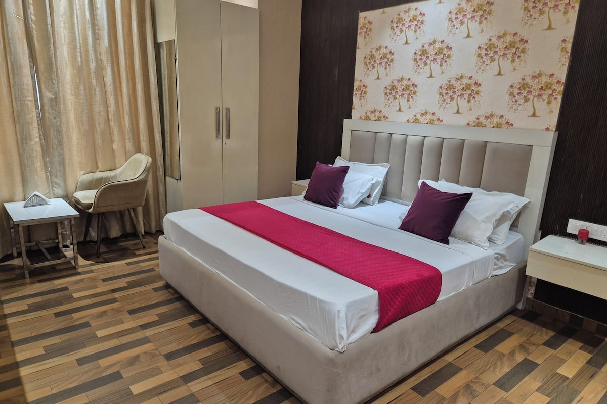 Quarto de hotel com cama, escrivaninha, cadeira e guarda-roupa.