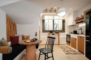 Uma cozinha compacta com armários de madeira, uma área de jantar com mesa redonda e um banco embutido.