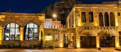 Um edifício histórico com janelas em arco, entrada central e uma placa com a inscrição 'Honey Hotel'.