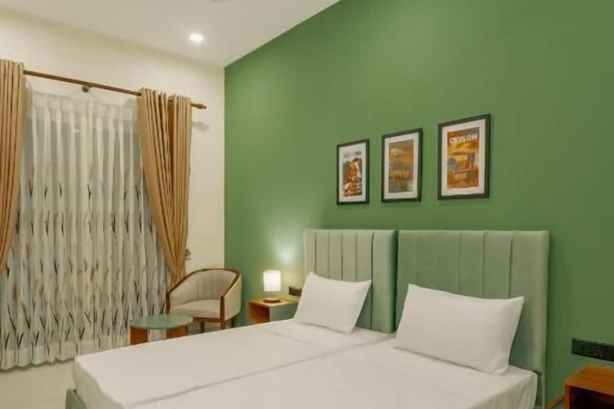Quarto com uma cama, um ventilador de teto, uma mesinha de cabeceira e uma cadeira.