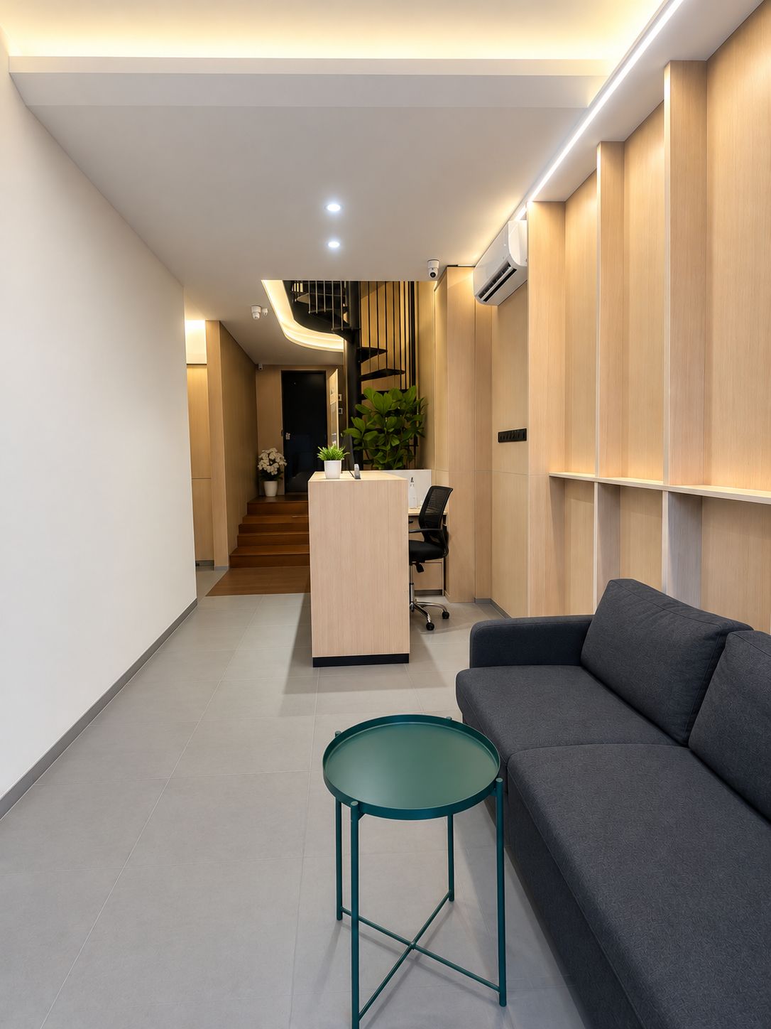 Uma área de recepção moderna, com balcão, sofá e uma pequena mesa.