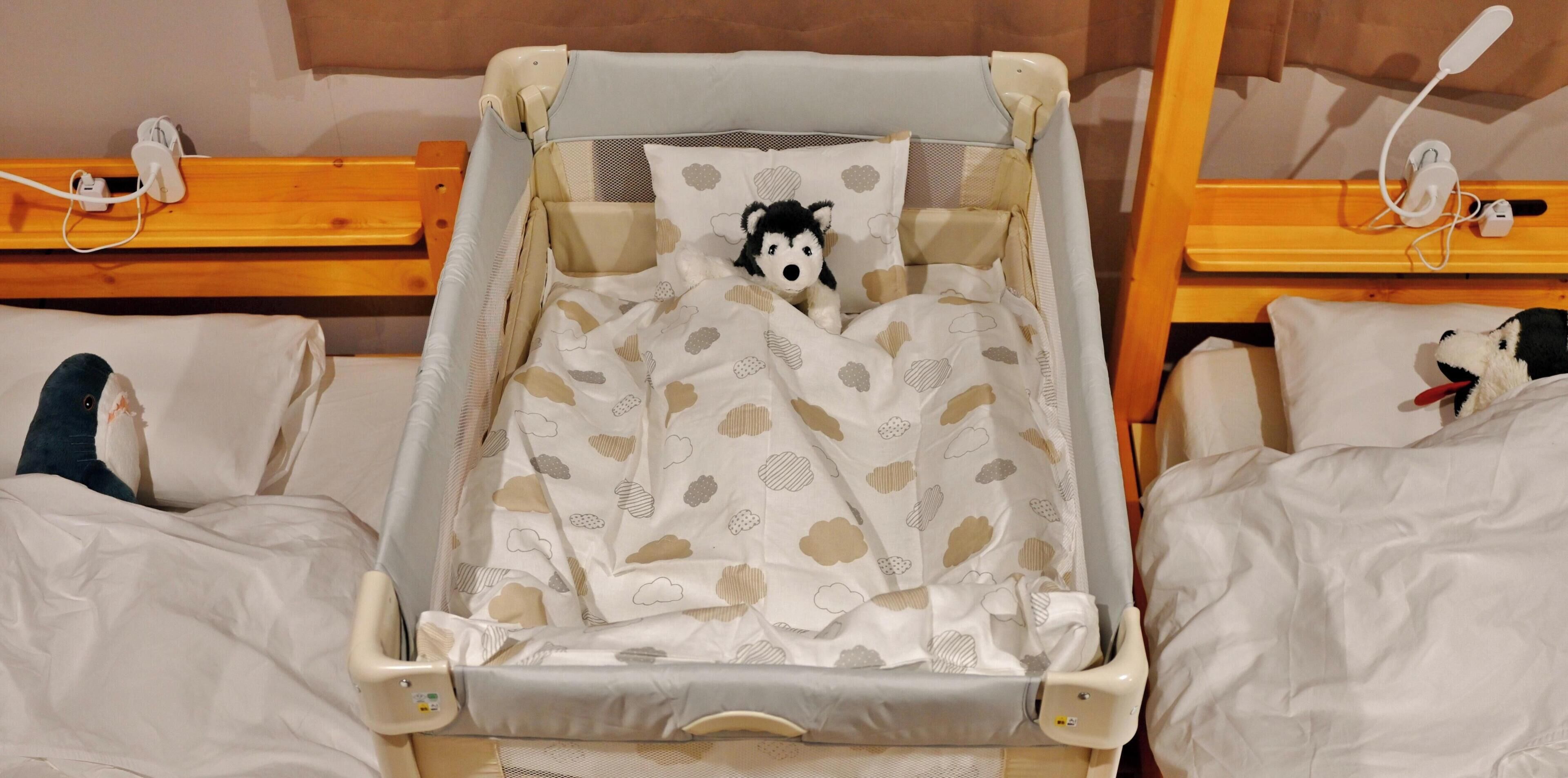 Uma cama de hospital com um cobertor estampado, um travesseiro com um personagem de desenho animado e um apoio para os pés.