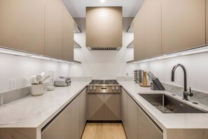 Cozinha moderna com ilha central, eletrodomésticos de aço inoxidável e uma bancada elegante.