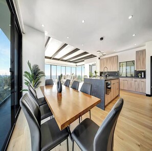 Uma cozinha moderna com armários de madeira, uma ilha central e uma grande janela com vista para a paisagem urbana.