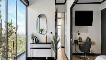 Um quarto moderno com uma janela grande, uma escrivaninha, uma cadeira e uma cama.