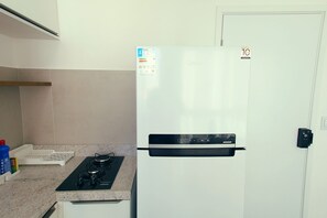 Uma cozinha com geladeira branca, fogão a gás e porta branca.