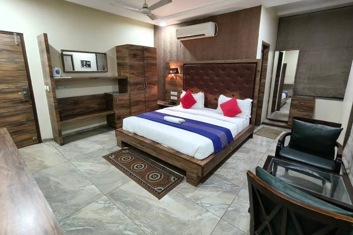 Quarto com cama, escrivaninha, cadeira, guarda-roupa e ar condicionado.