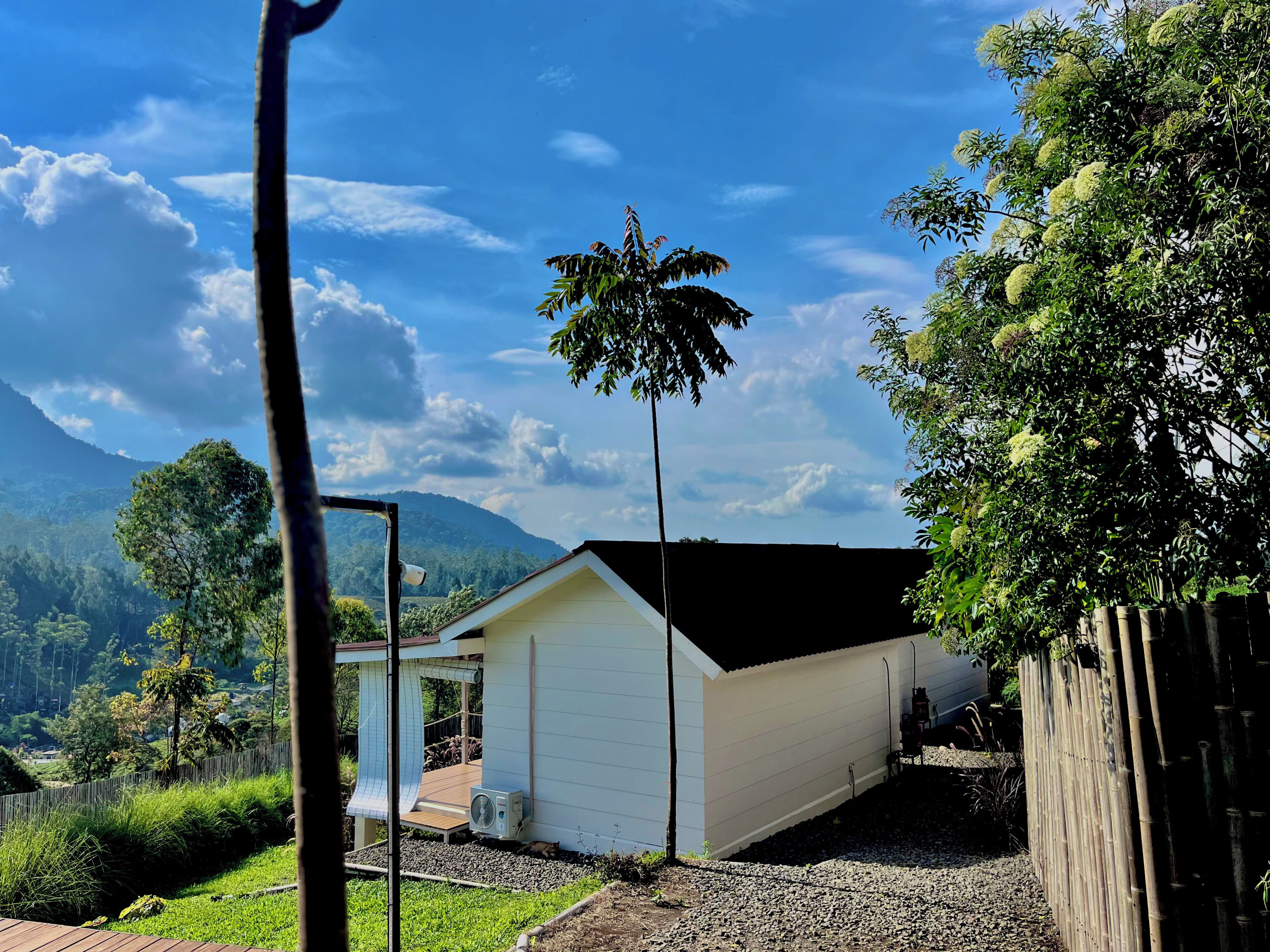 Uma casa com fachada branca, um deck de madeira e vista para uma cordilheira.