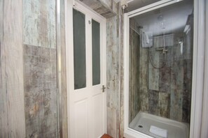 Casa de banho com chuveiro, porta e janela.