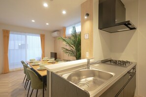Uma cozinha moderna com uma pia de aço inoxidável, um fogão a gás e um armário de madeira.
