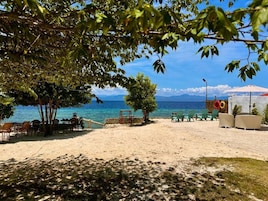 Uma praia com área externa, mesa e cadeiras.
