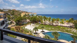 Resort com piscina, praia e vista para o oceano.