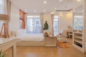 Um quarto moderno com uma cama grande, mesas de cabeceira, uma escrivaninha e um espelho.