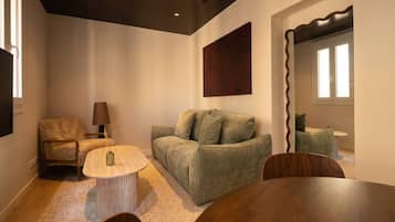 Uma sala de estar moderna com sofá, poltronas, mesa de centro e mesa de jantar.