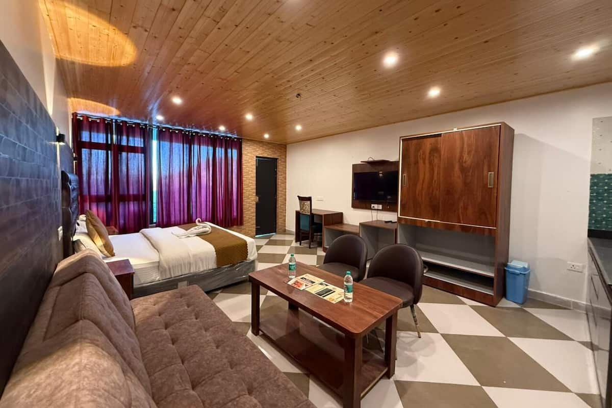Quarto de hotel moderno com cama, sofá, televisão, armário de madeira e chão xadrez.