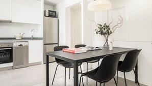 Uma cozinha moderna com armários brancos, forno embutido e micro-ondas.