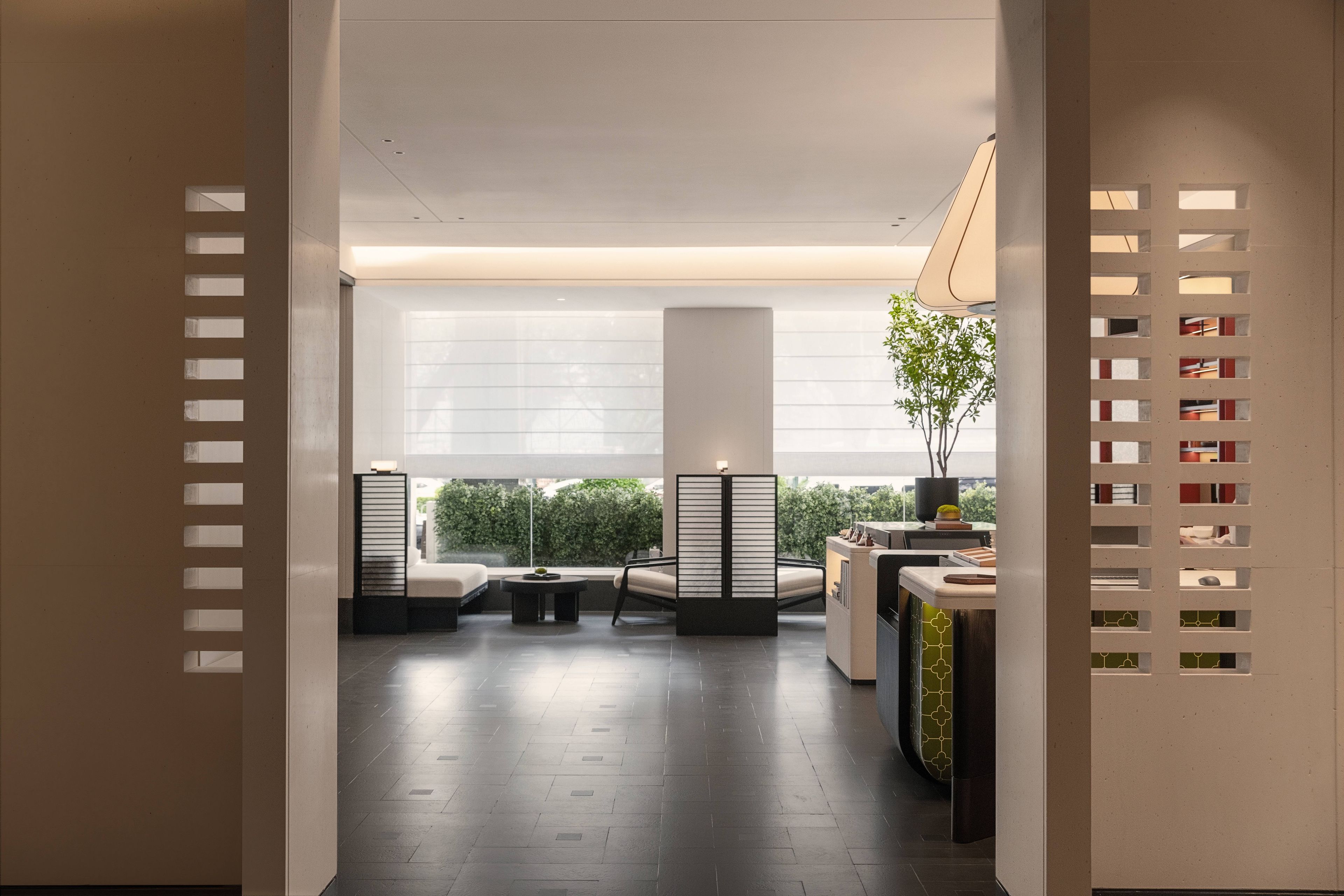 Interior moderno com área de estar, planta em vaso e vista pela janela.