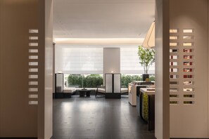 Interior moderno com área de estar, planta em vaso e vista pela janela.