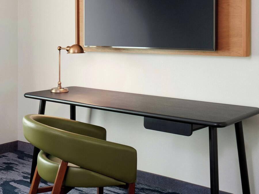 Uma mesa com uma lâmpada, uma cadeira e um quadro-negro.
